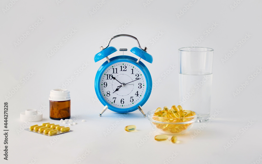 Time to take your pills. An alarm clock on a white background shows the ...