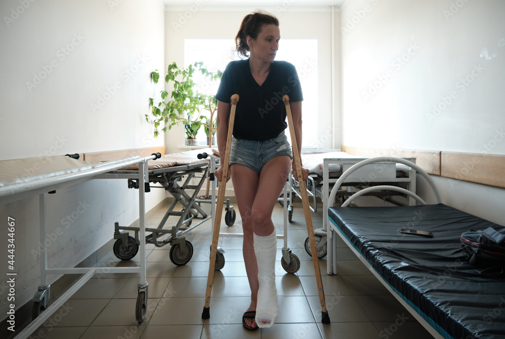 A woman with a broken leg uses orthopedic crutches. Leg injury. Loss of ...