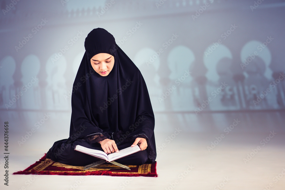 Young beautiful Muslim woman in black Islam chador reading Quran and ...