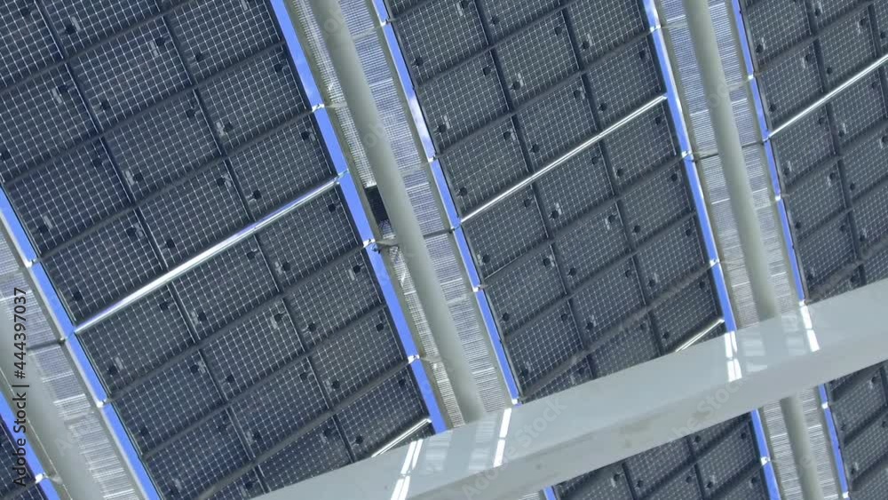 Rotating low-angle shot over big solar panel structure. Back view of ...