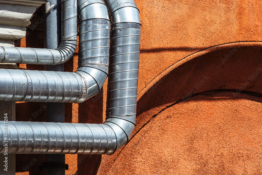 Ventilation pipes on the background of a red wall. Air conditioning ...