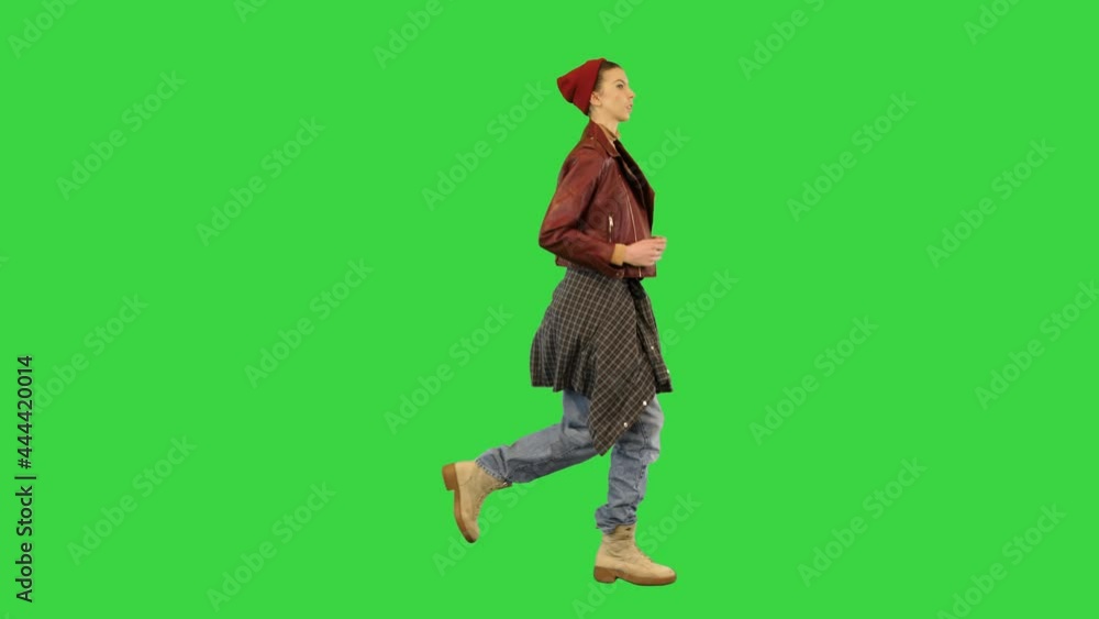 Young girl in stylish urban clothes runs slowly on a Green Screen ...