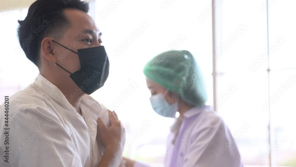 Young asian man patient giving his arm to nurse for injection ...