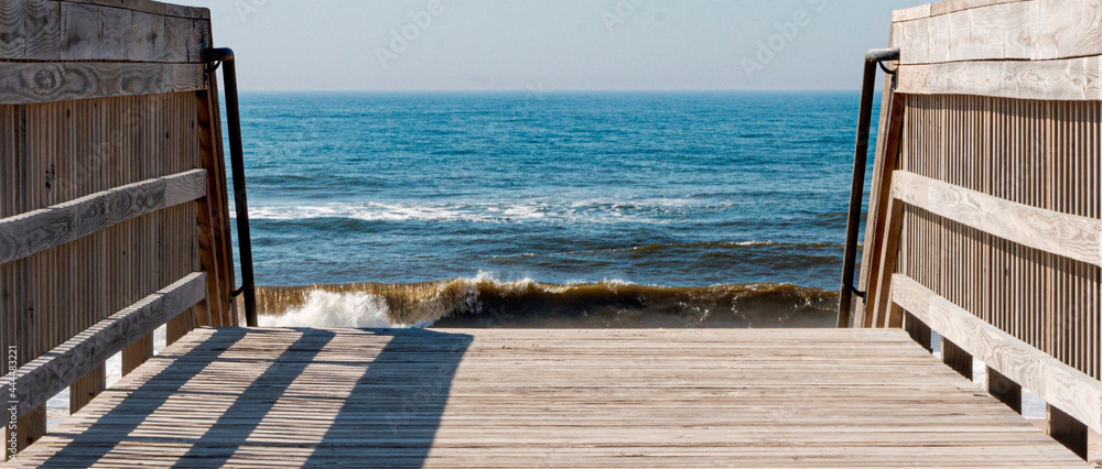 Looking at the Atlantic Ocean from a wooden walkway going over the sand ...