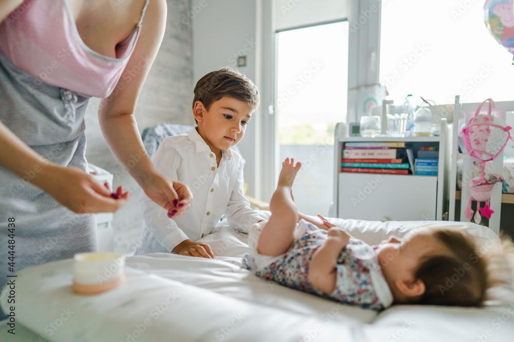 Small caucasian boy four years old helping his mother changing diapers ...