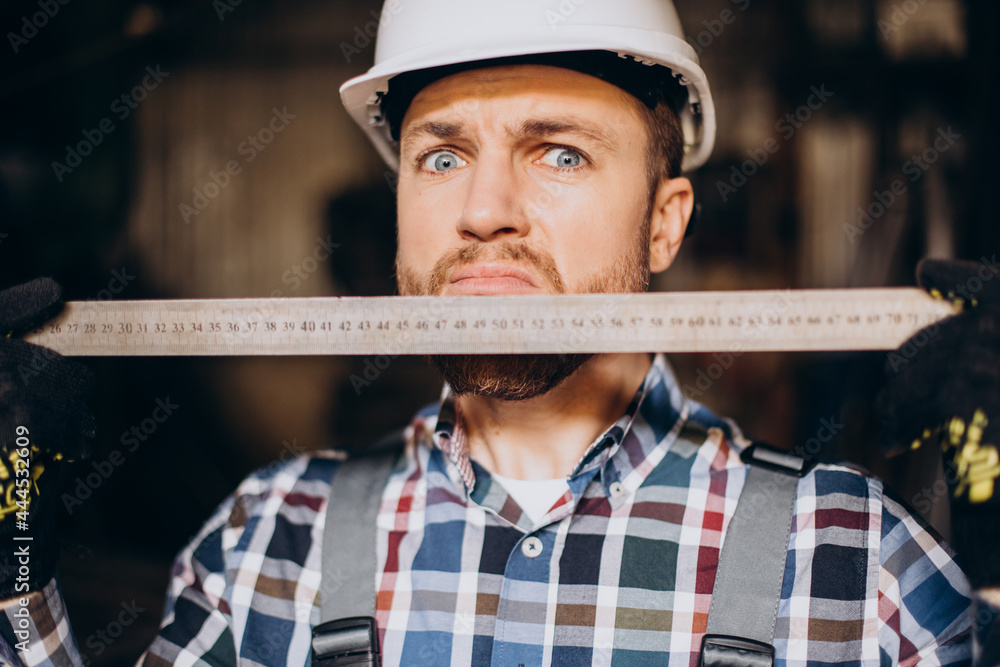 Workman wearing har hat with measuring ruler at factory foto de Stock ...
