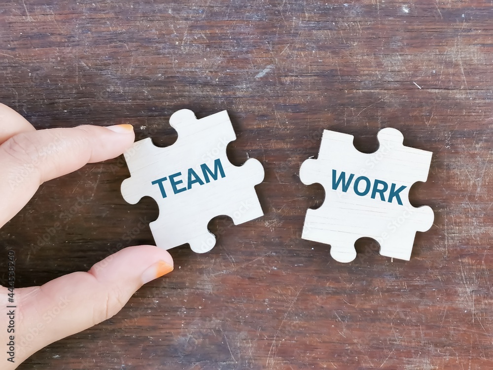 Teamwork concept. Phrase teamwork written on jigsaw puzzle with hand ...
