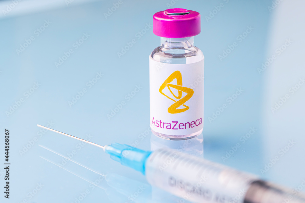 vaccination syringe and a glass ampoule with a clear liquid on a blue ...