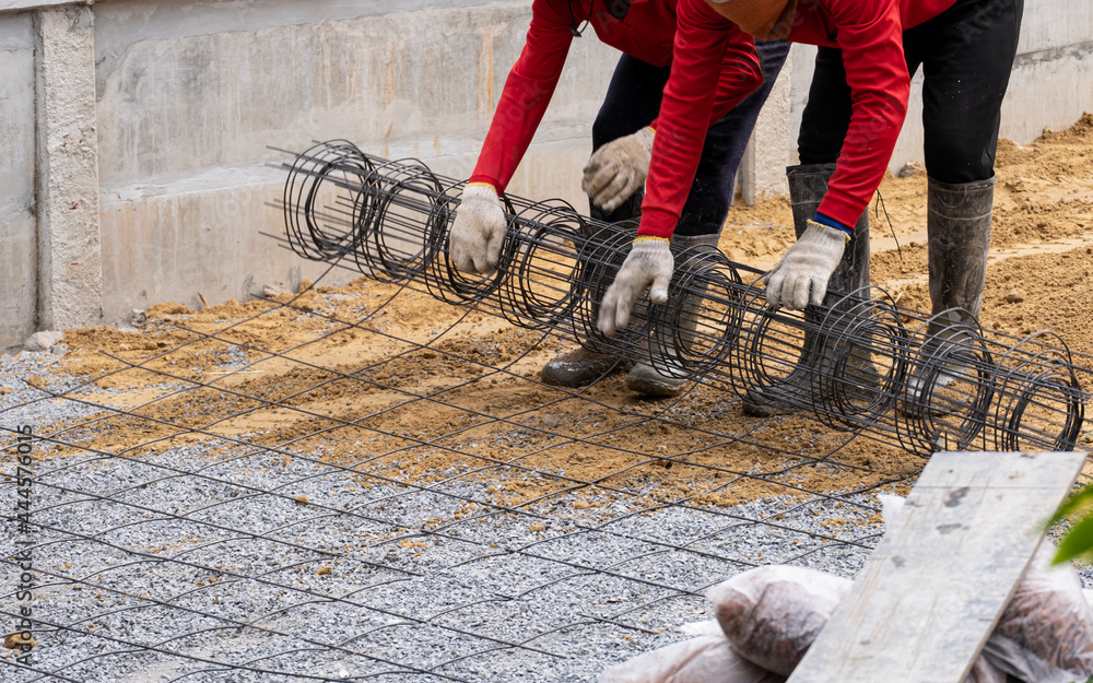 two worker team work install wire mesh on sand floor for reinforce ...
