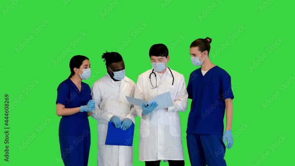 Multiracial group of young doctors discuss on documents on a Green ...