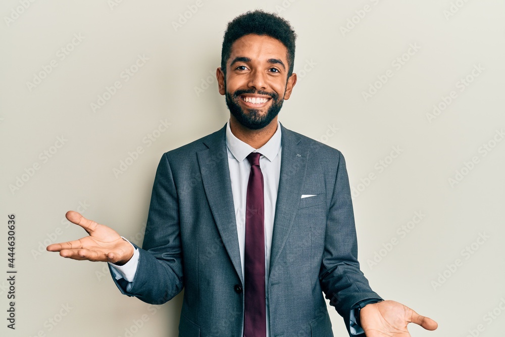 Handsome hispanic man with beard wearing business suit and tie smiling ...