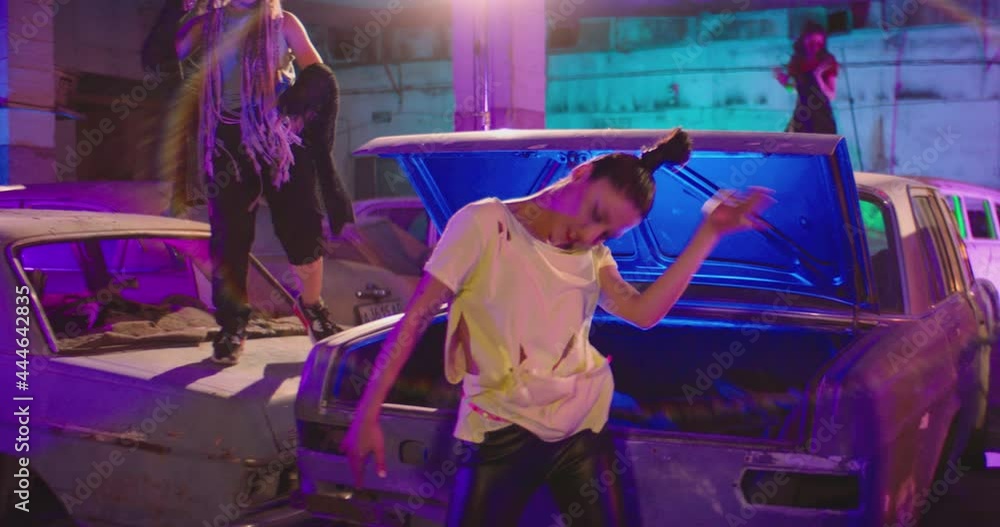 Group of stylish young people dancing , moving inside abandoned garage ...