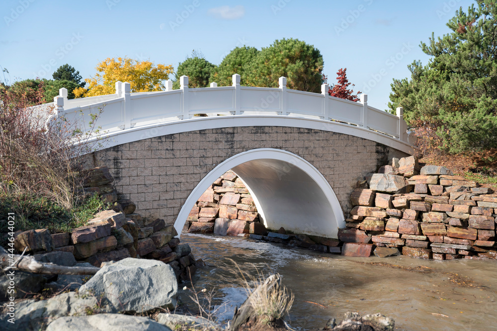 Arched concrete bridge over a river with white railing Stock Photo ...