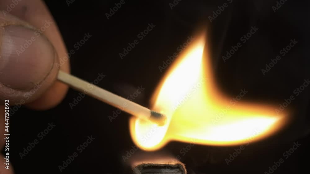 Slow motion. Ignition of a match by rubbing against a matchbox. Man ...