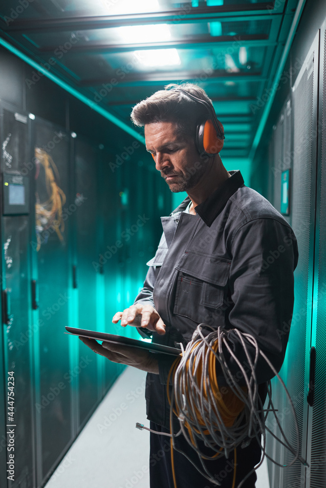 Vertical side view portrait of mature network engineer using digital ...