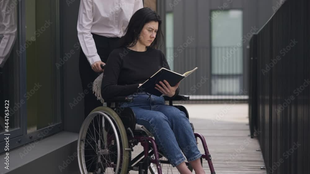 Absorbed concentrated disabled woman reading paperwork as ...