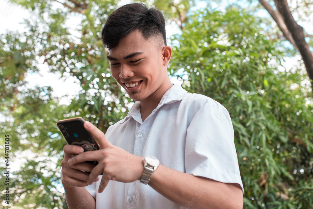 A Filipino teenager busily chats on the phone or watches trending viral ...