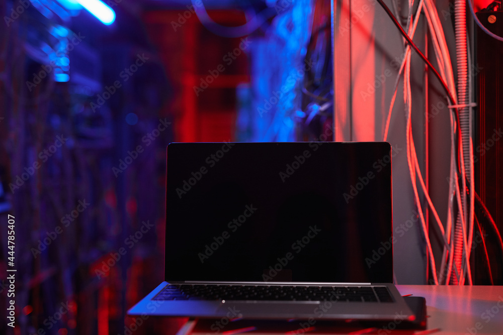 Background image of blank laprop screen in dark server room, copy space ...
