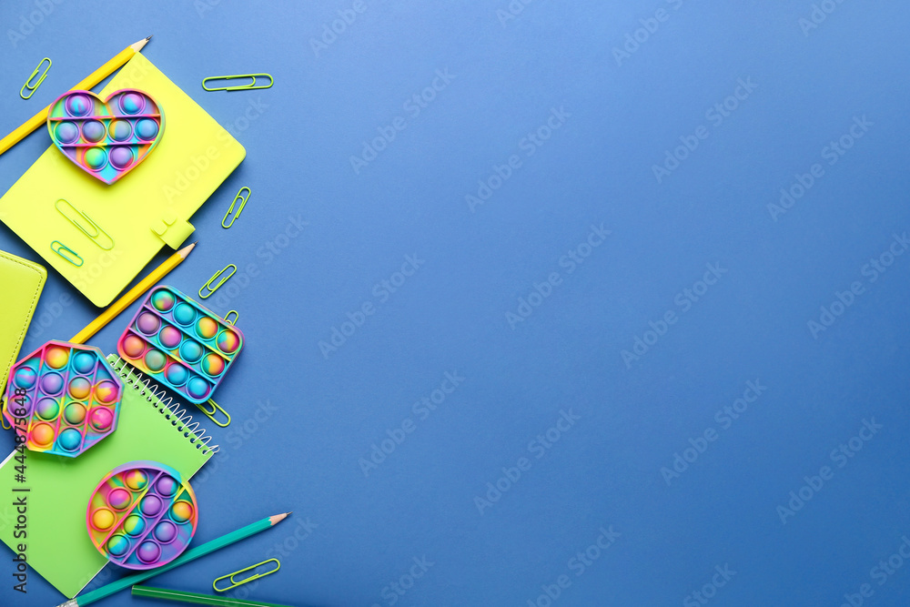 Pop it fidget toys and stationery on color background Stock Photo ...