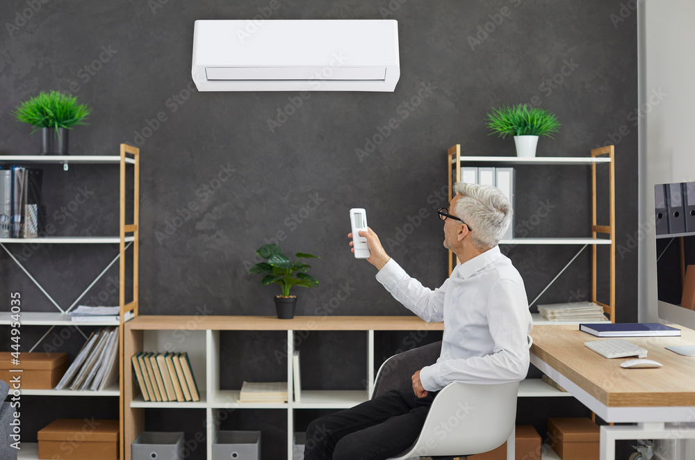 Man switches AC at work. Senior businessman, company worker or ...