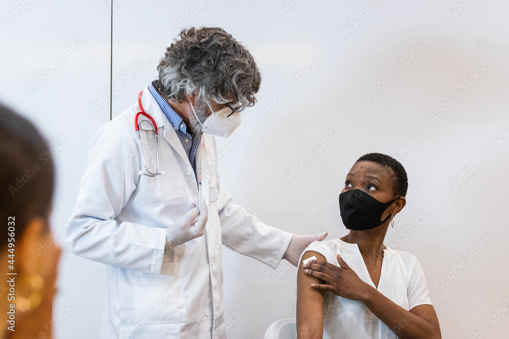 Doctor making injection for black woman patient Stock Photo | Adobe Stock