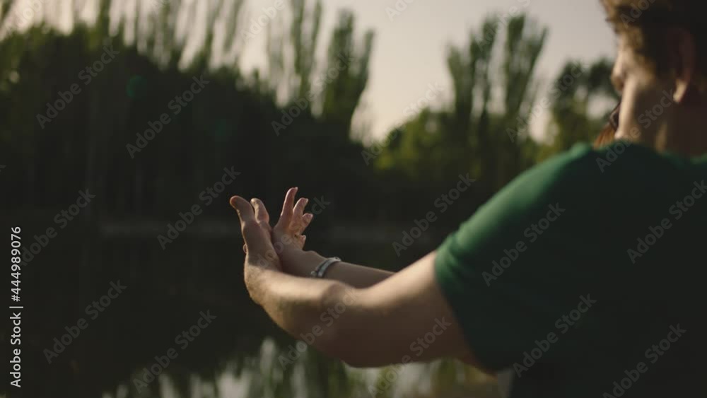 Back rear view of young couple standing by the lake or sea looking at ...