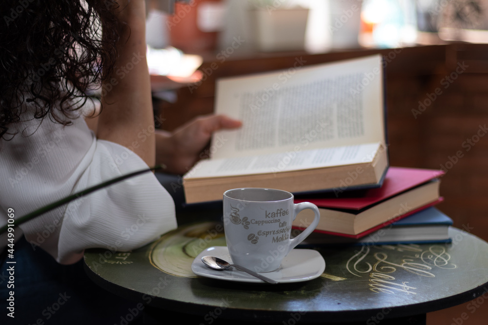 Mujer tomando café y leyendo un libro Stock Photo | Adobe Stock
