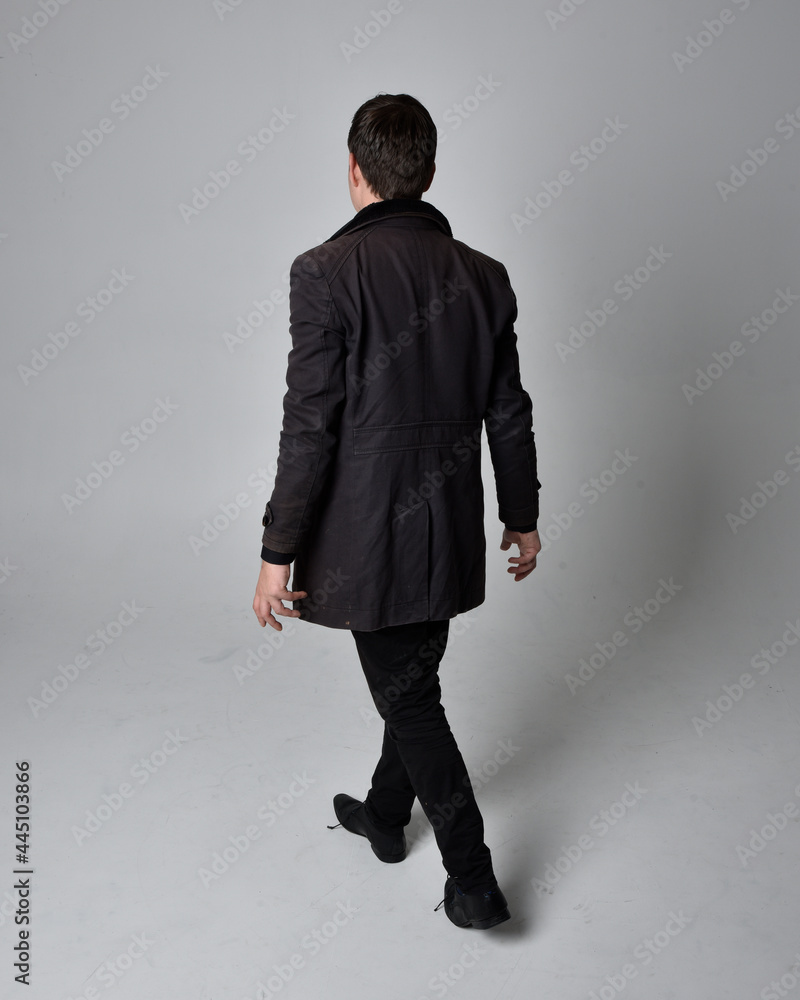 Full length portrait of a brunette man wearing black leather coat ...
