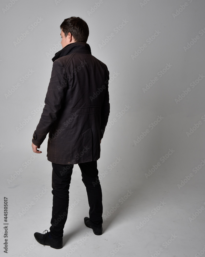 Full length portrait of a brunette man wearing black leather coat ...