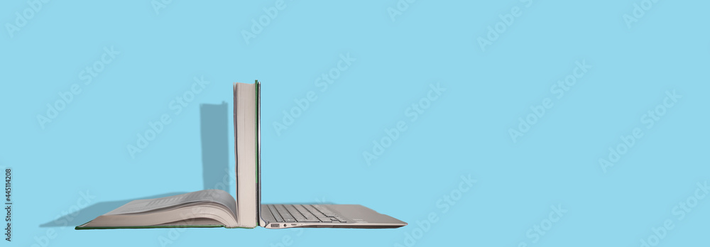 Banner with modern laptop computer positioned back to back with a thick ...