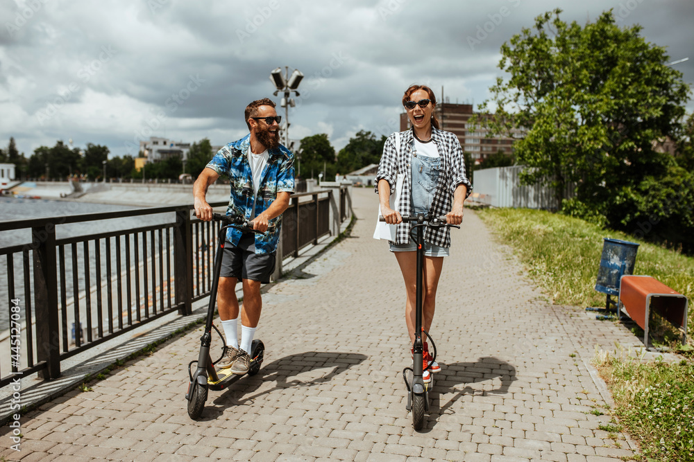 Portrait of a modern young couple on vacation having fun riding on ...