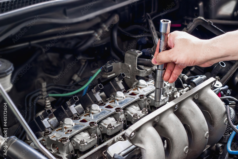Hand a man checking automobile valve system in the engine room service ...
