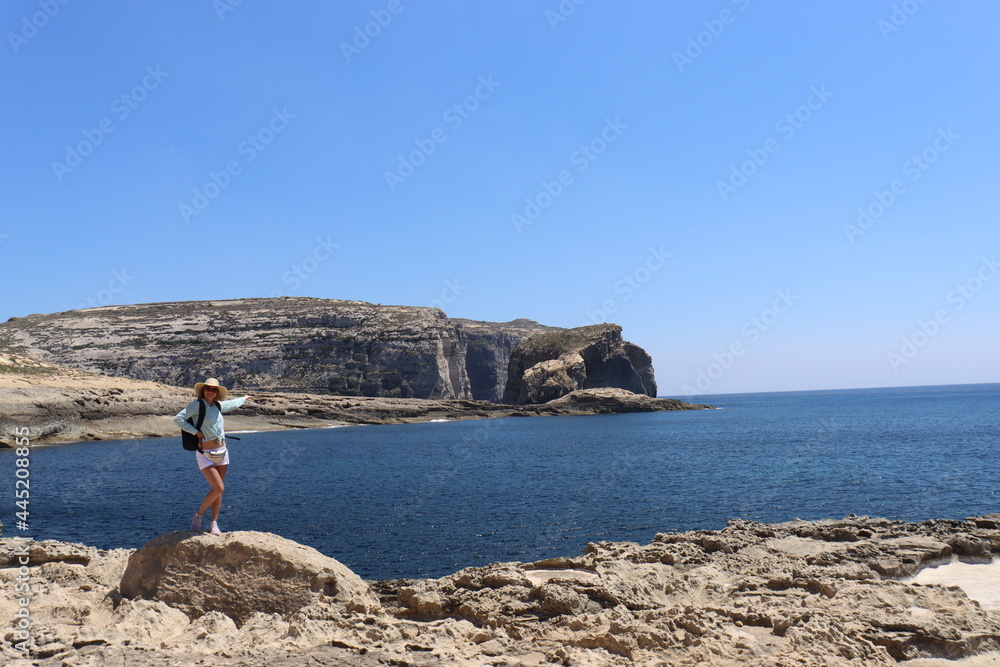 European girl overlooking the blue hole azure window in Malta Gozo ...