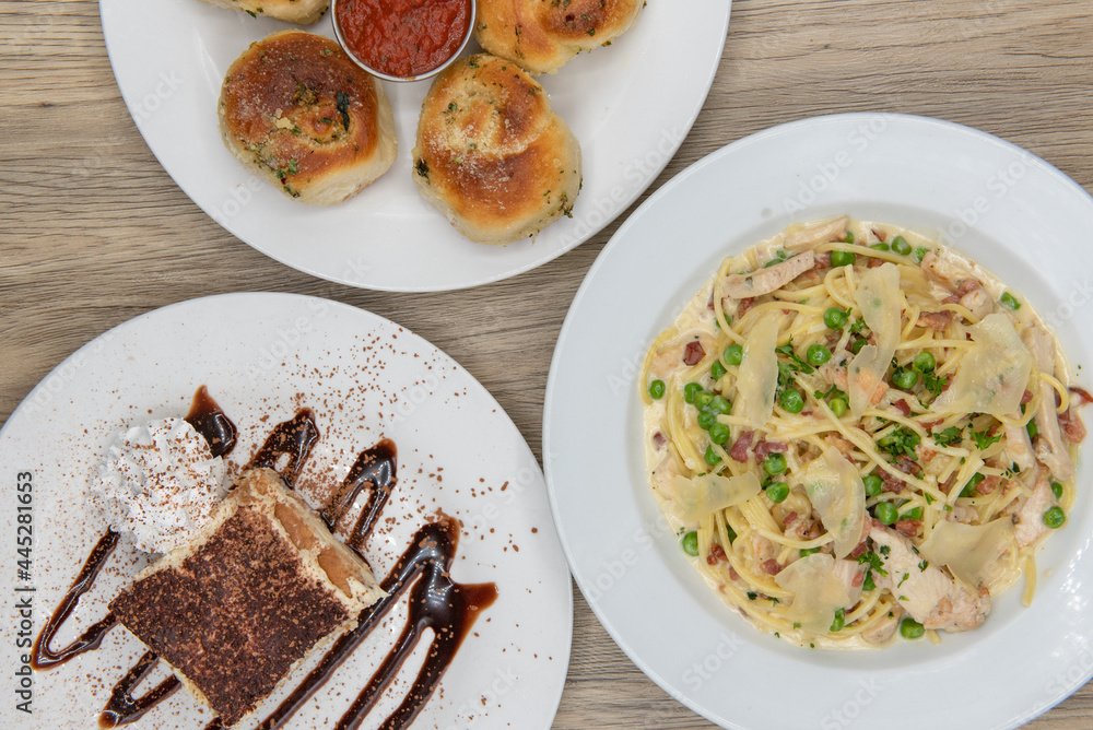 Overhead view of a 3 course meal consisting of garlic bread appetizer ...