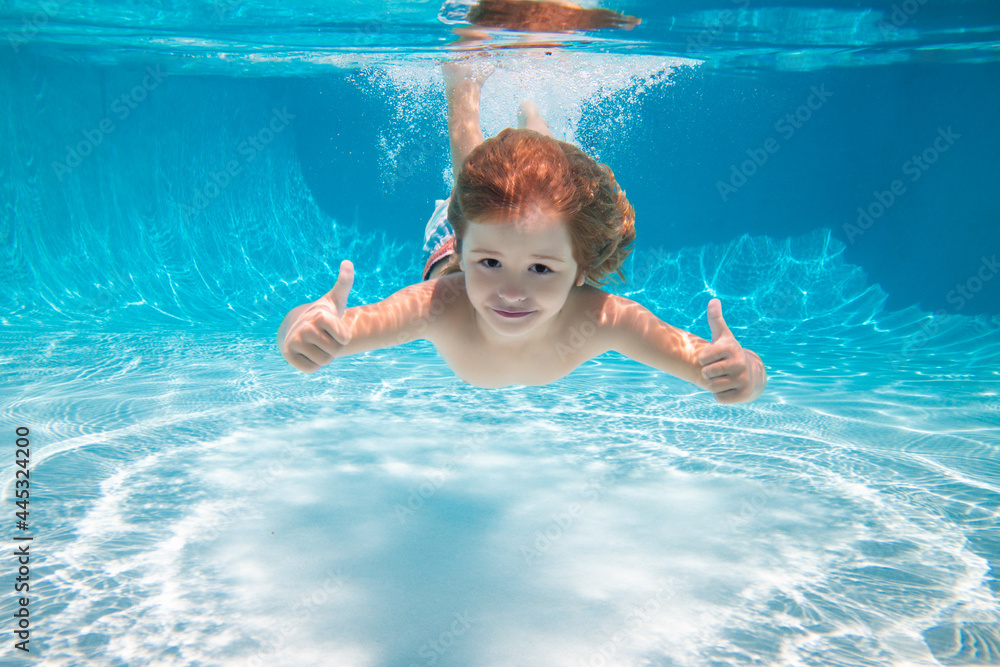 Child swimming underwater with thumbs up. Underwater kid swim under ...