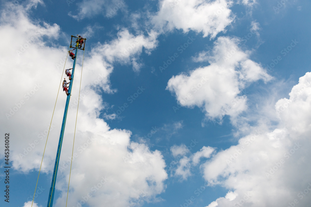 A group of voladores (flyers) climbing the pole to perform the ...