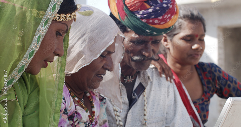 Group of indian people with traditional attire looking at a device ...