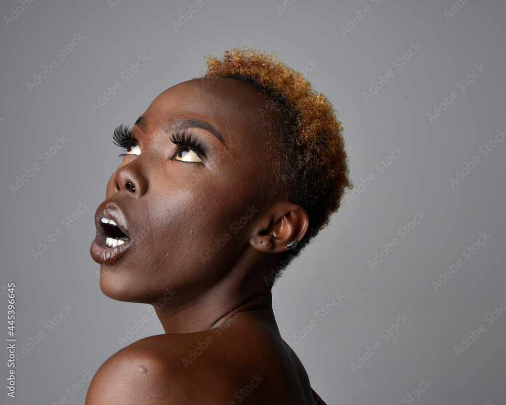 Close up head and shoulders portrait of a pretty young African woman ...