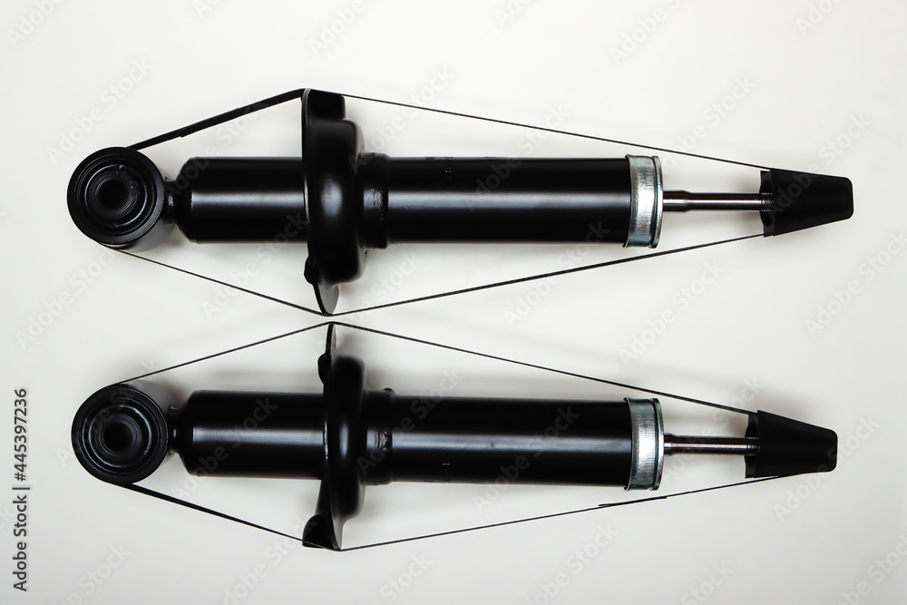 Two new shock absorbers for the car on a flat surface. A set of spare ...