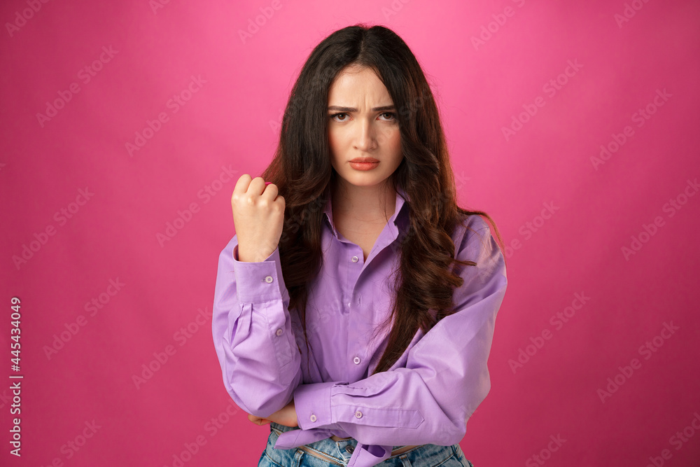 Young beautiful sad woman serious and worried, pink studio background ...