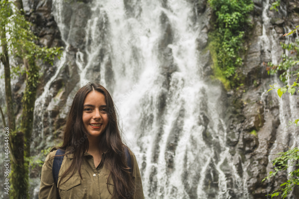 Adventurous girl exploring waterfalls in the middle of the jungle, with ...