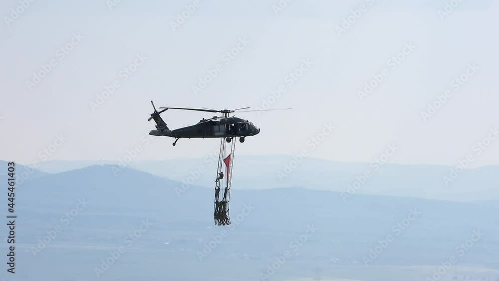 People hanging from helicopter performing stunt flying.Aerobatics ...