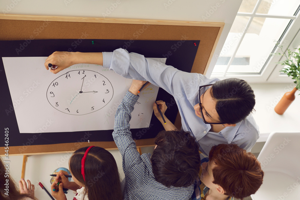 Education and development, timing teaching. Female teacher explaining ...