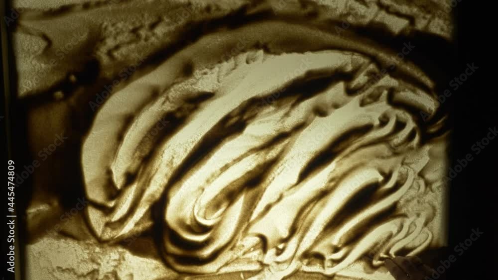 Sand animation. Hand drawing in the sand on the light box. A woman ...