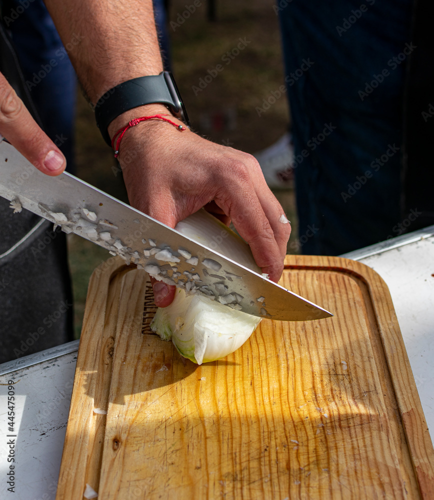 manos cortando vegetales sobre tabla de madera. anos cortando cebolla ...