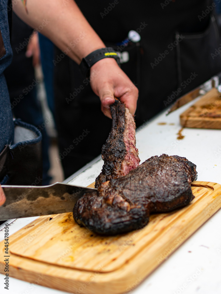 corte asado directo al carbón. cowboy asado cavernícola. manos cortando ...