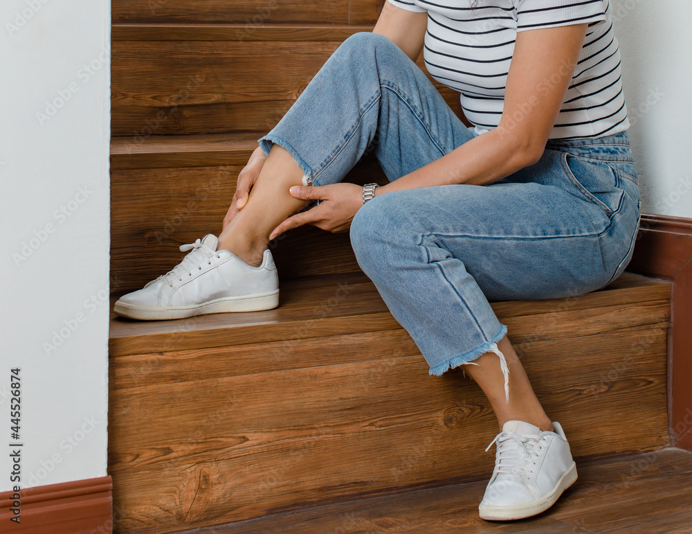 Woman cannot walk climb stair, she stops and use hand hold leg with ...