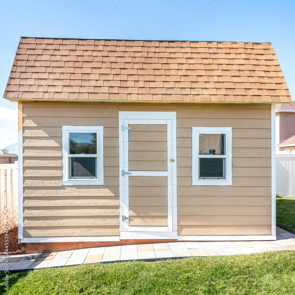 Square frame Shed at a backyard with roof shingles and vinyl wall ...