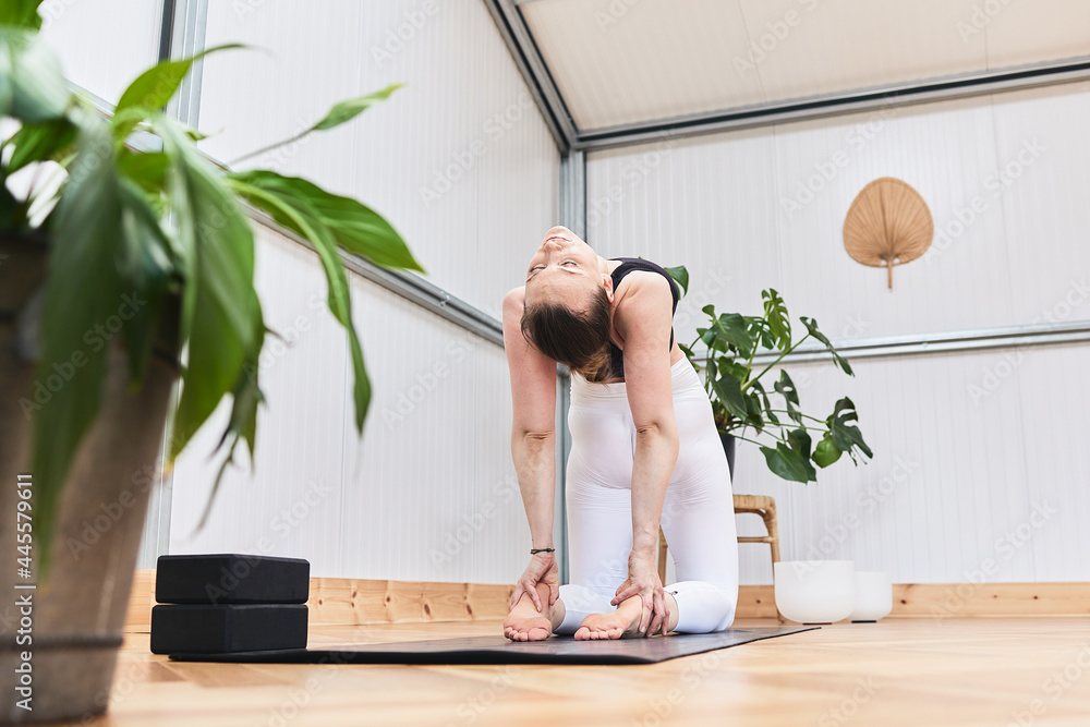 Caucasian woman stretching her back, forming an arch to perform a ...