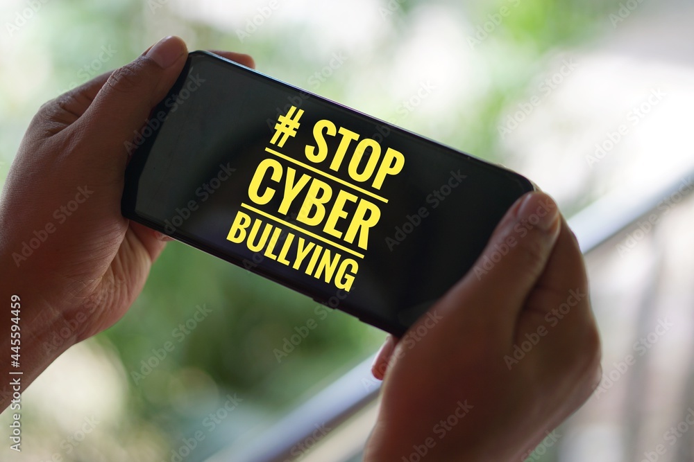 Text "STOP CYBERBULLYING" on screen of mobile phone. Concept : calling ...